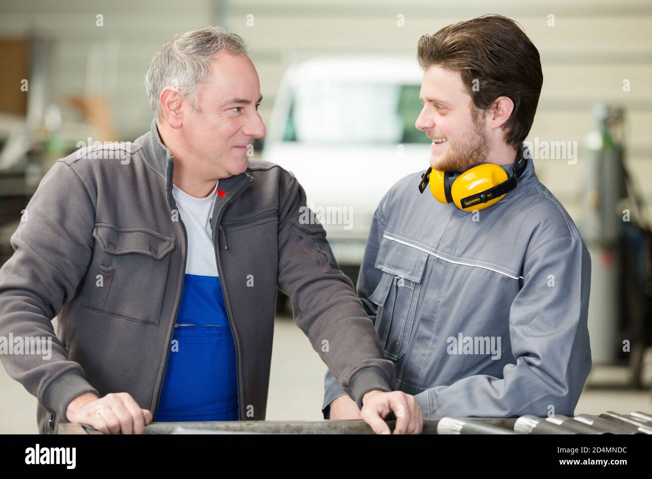 portrait of two smiling garage workers Stock Photo - Alamy