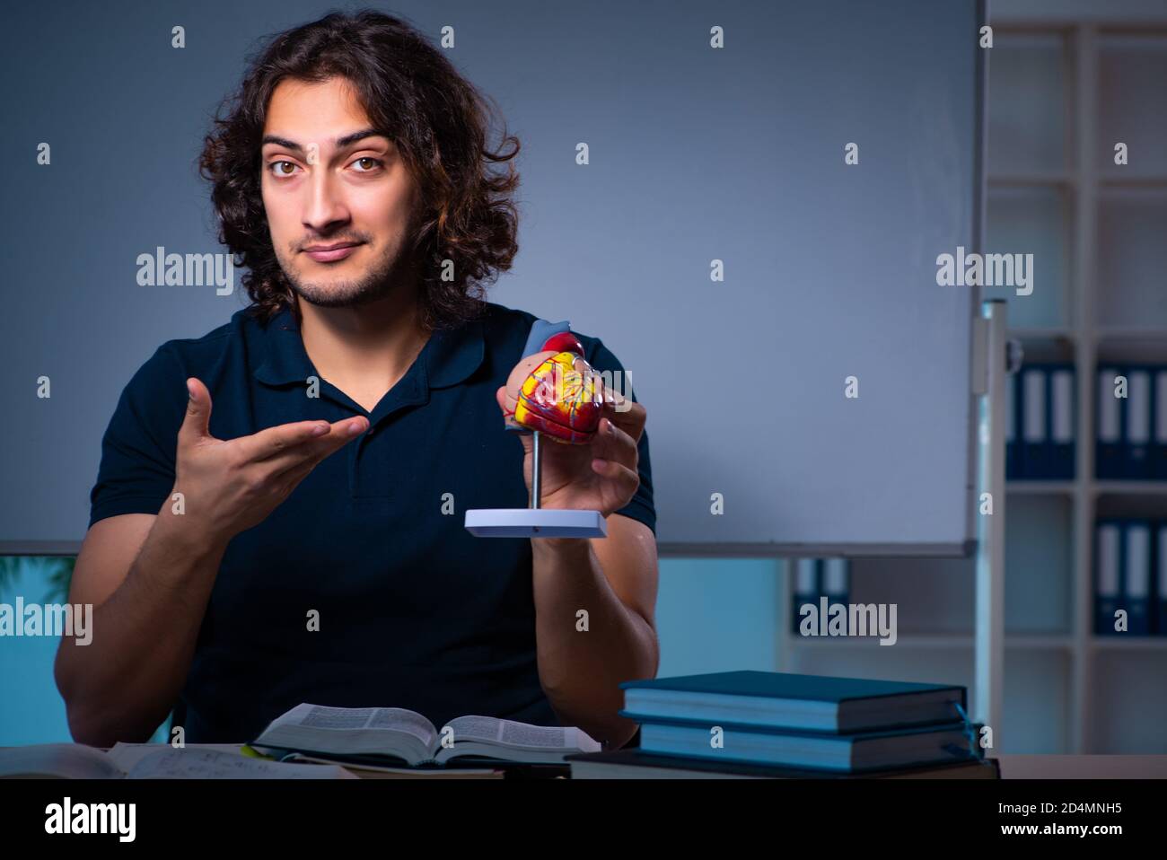 Young student in the classroom at night Stock Photo - Alamy