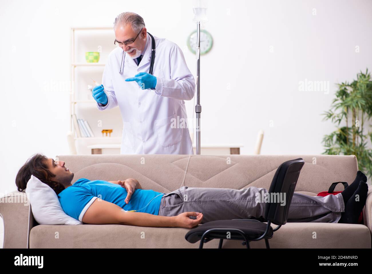 Two doctors visiting sick man at home Stock Photo - Alamy