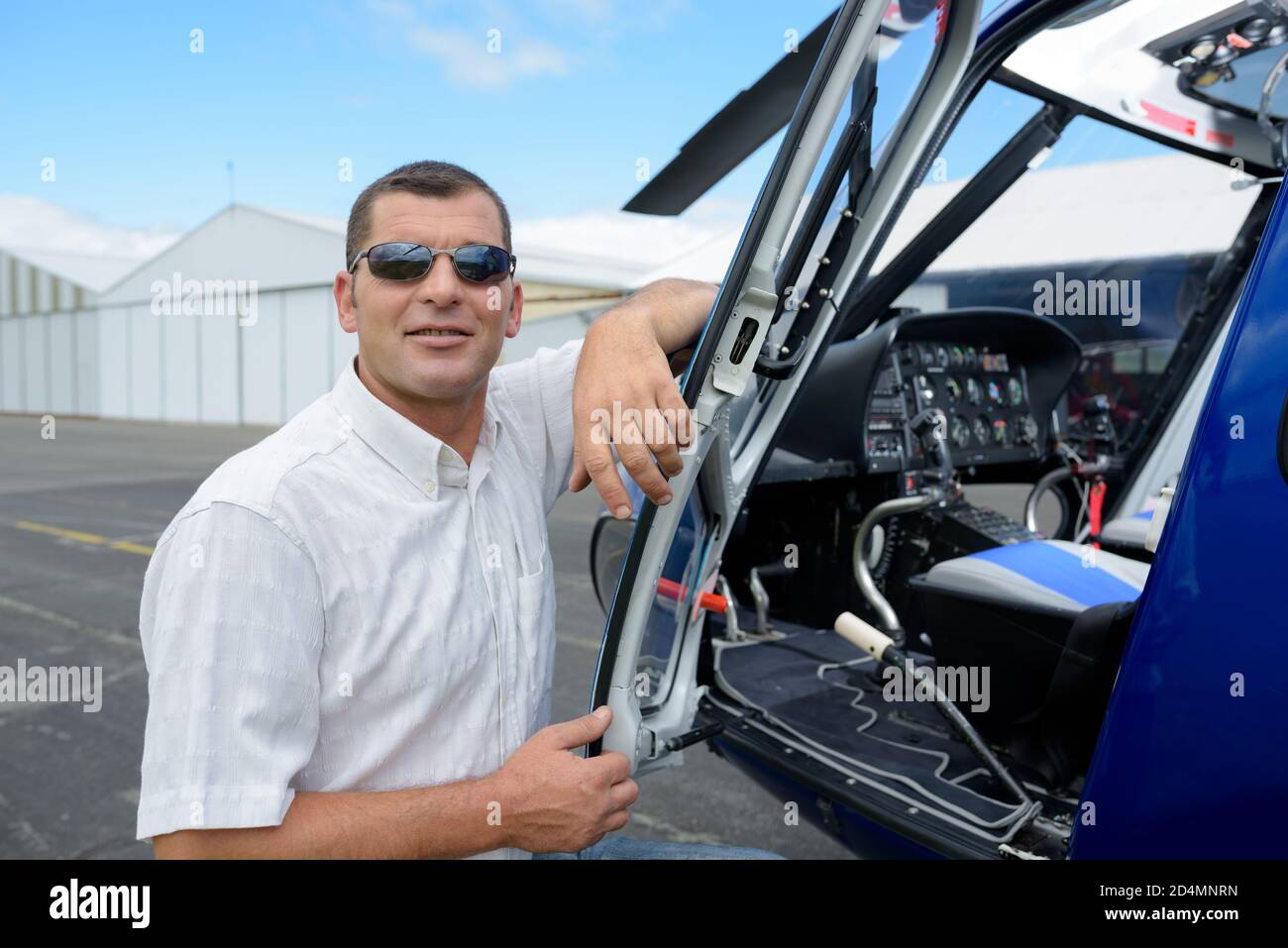 portrait of pilot standing in front of helicopter Stock Photo - Alamy