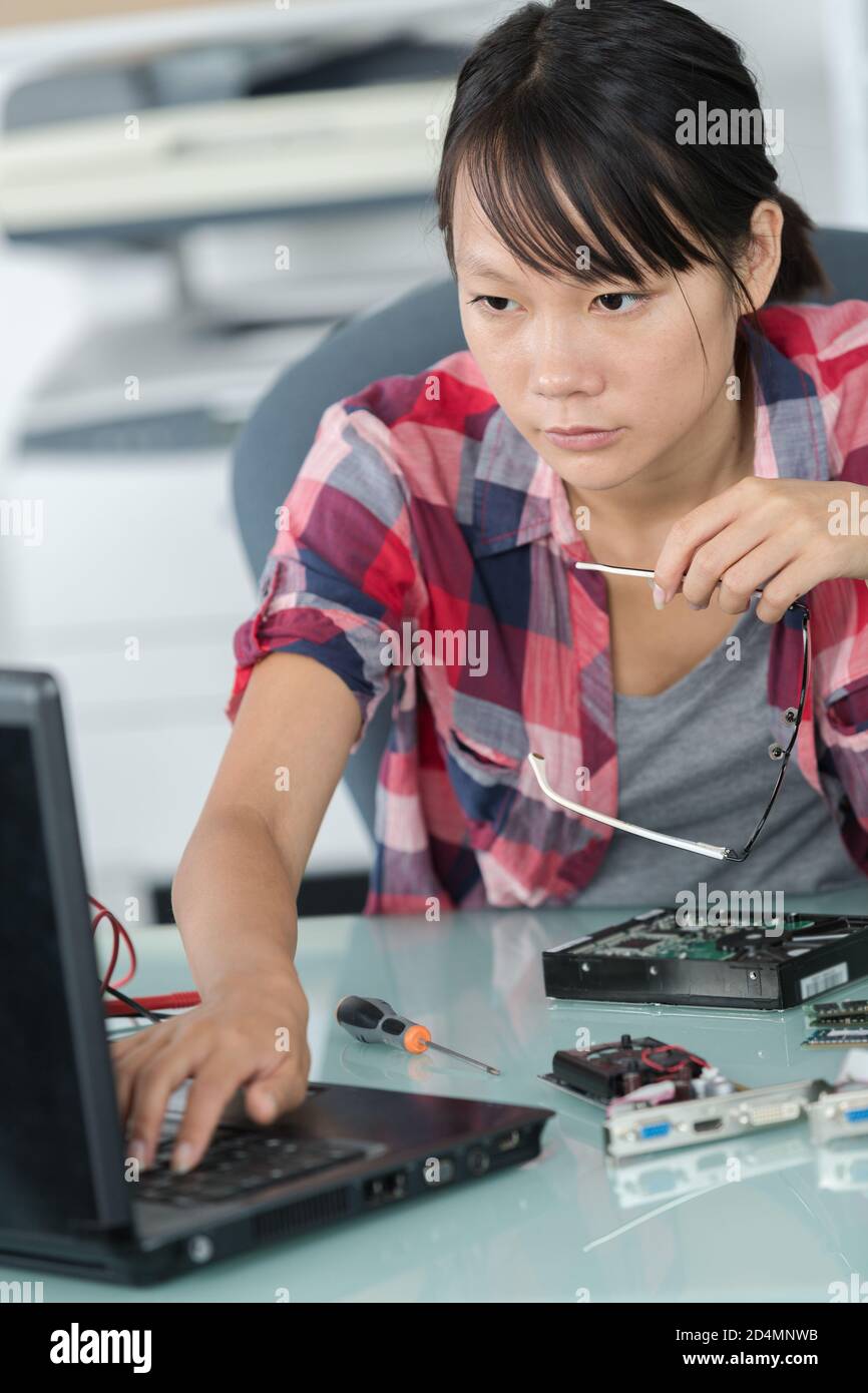 female asian computer technician using laptop Stock Photo - Alamy