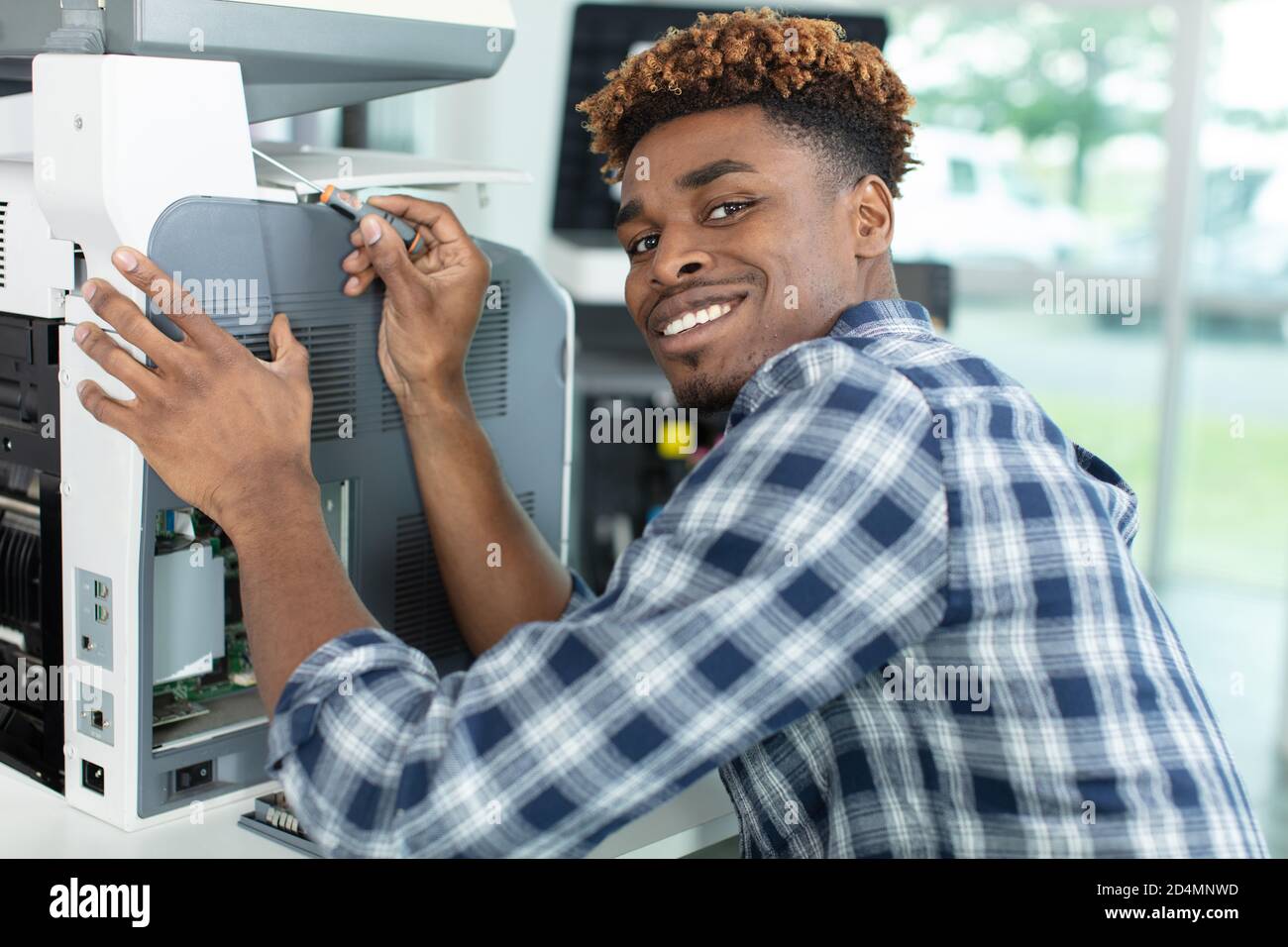 concentrated man fixing a printer Stock Photo - Alamy