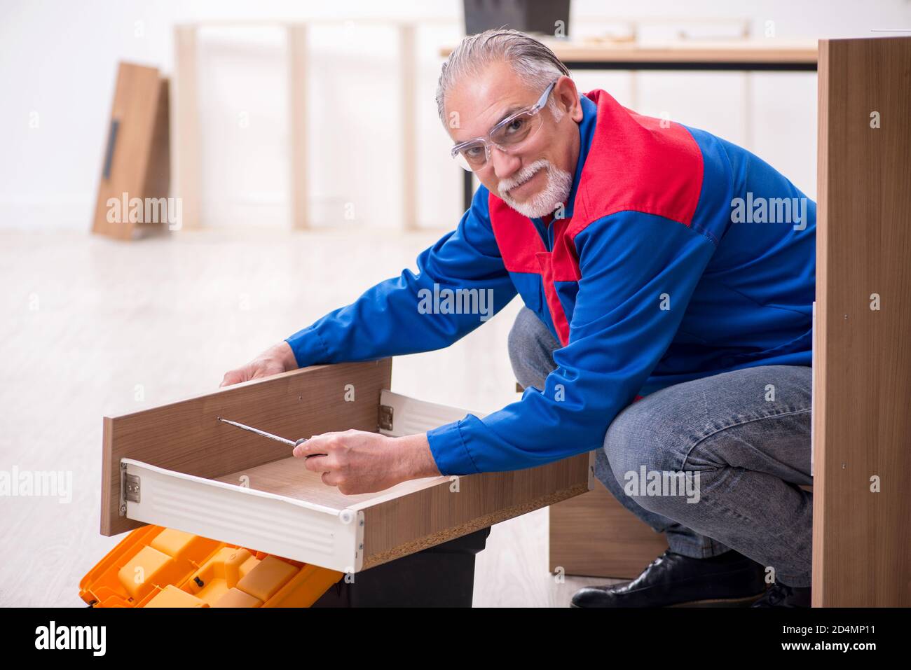 Old carpenter working indoors on furniture Stock Photo - Alamy
