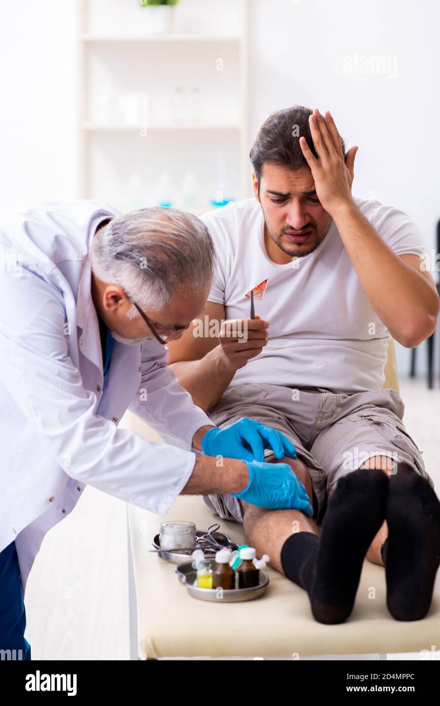 Leg injured man visiting doctor in first aid concept Stock Photo - Alamy