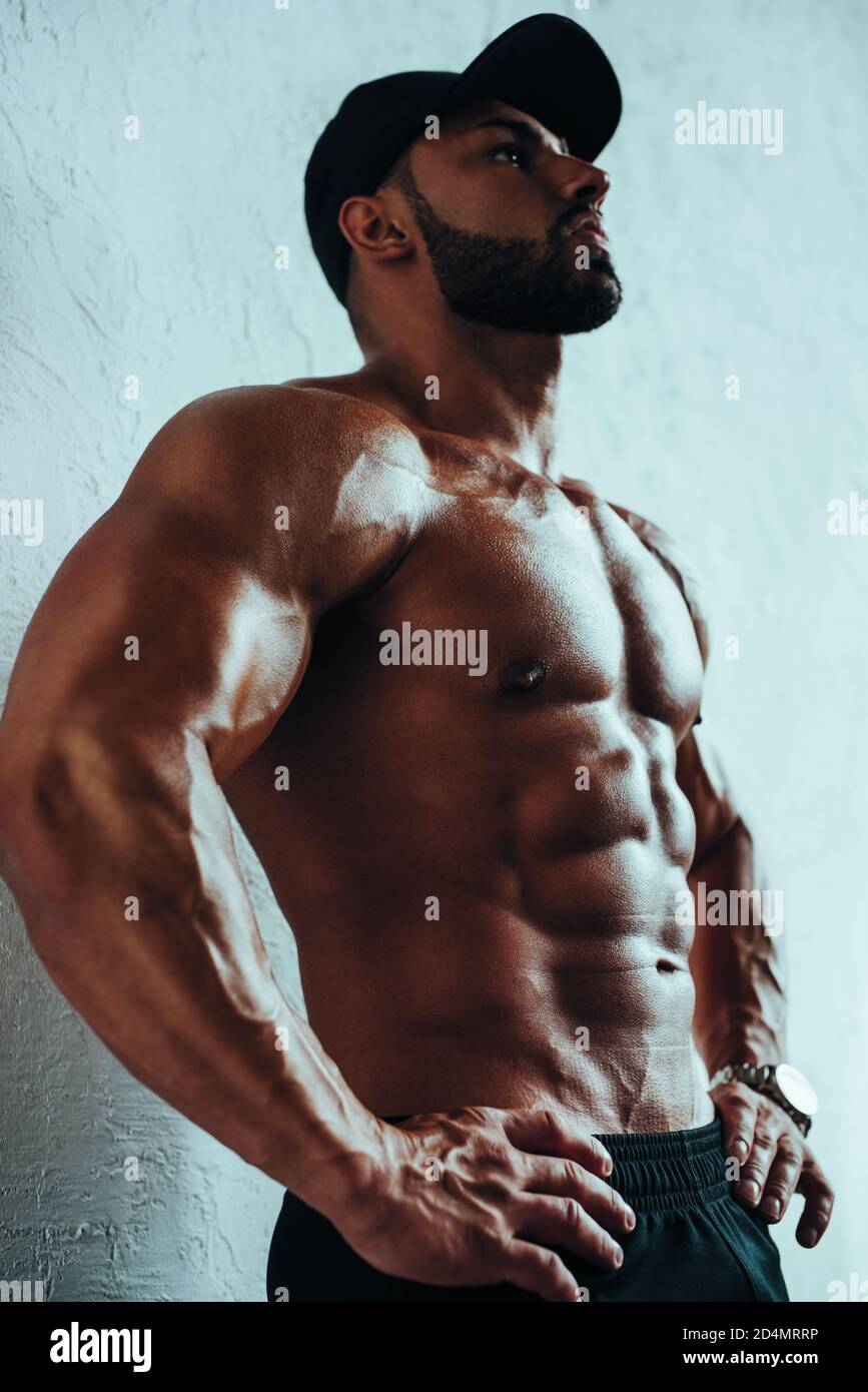 Young strong man bodybuilder in cap on white wall background Stock ...