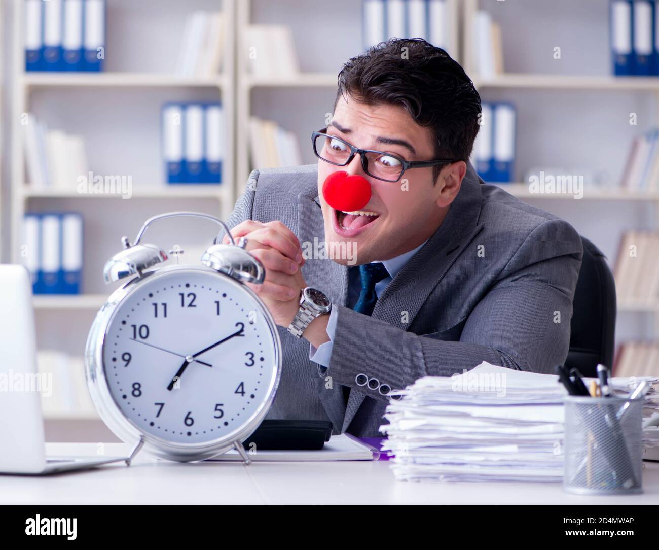 Clown businessman with alarm clock missing dieadline Stock Photo - Alamy