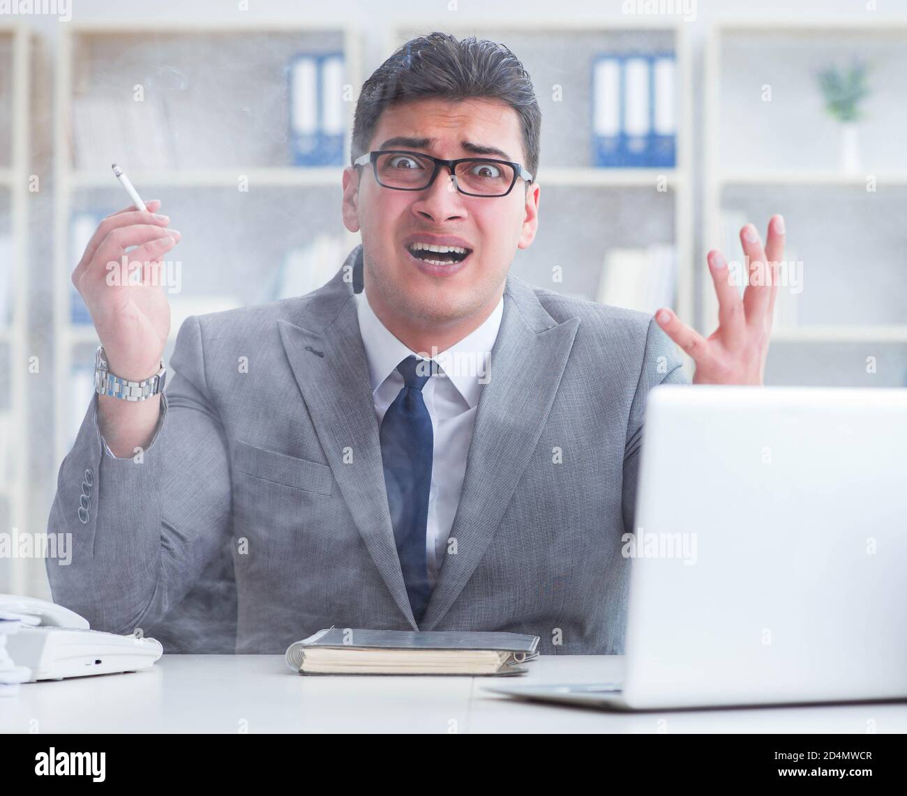 The businessman smoking in office at work Stock Photo - Alamy