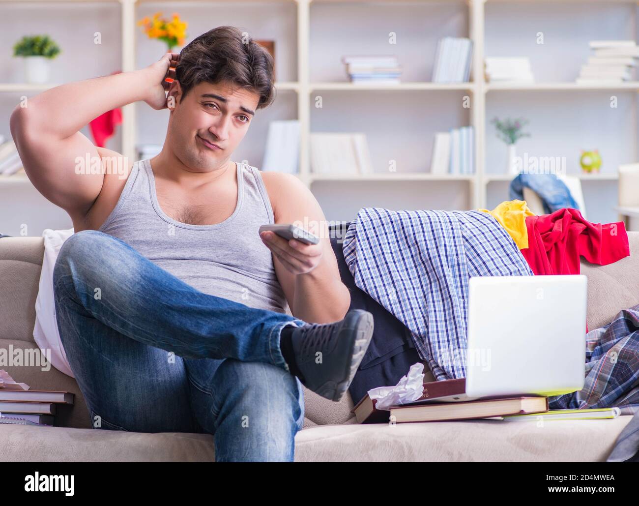 Young man working studying in messy room Stock Photo - Alamy