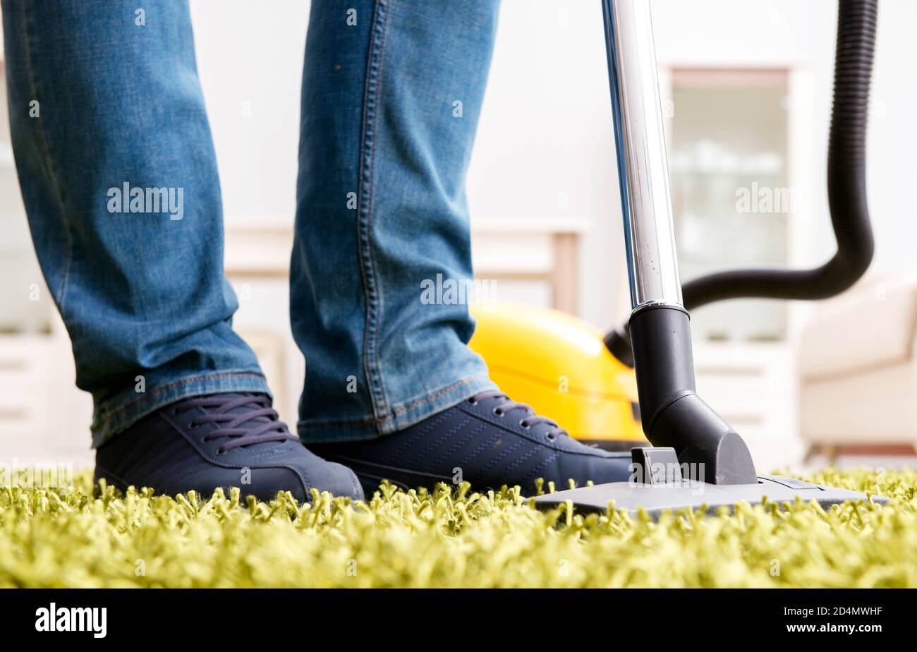 The man cleaning the floor carpet with a vacuum cleaner close up Stock ...