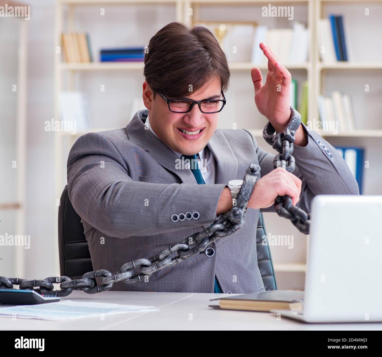 The businessman tied with chains to his work Stock Photo - Alamy