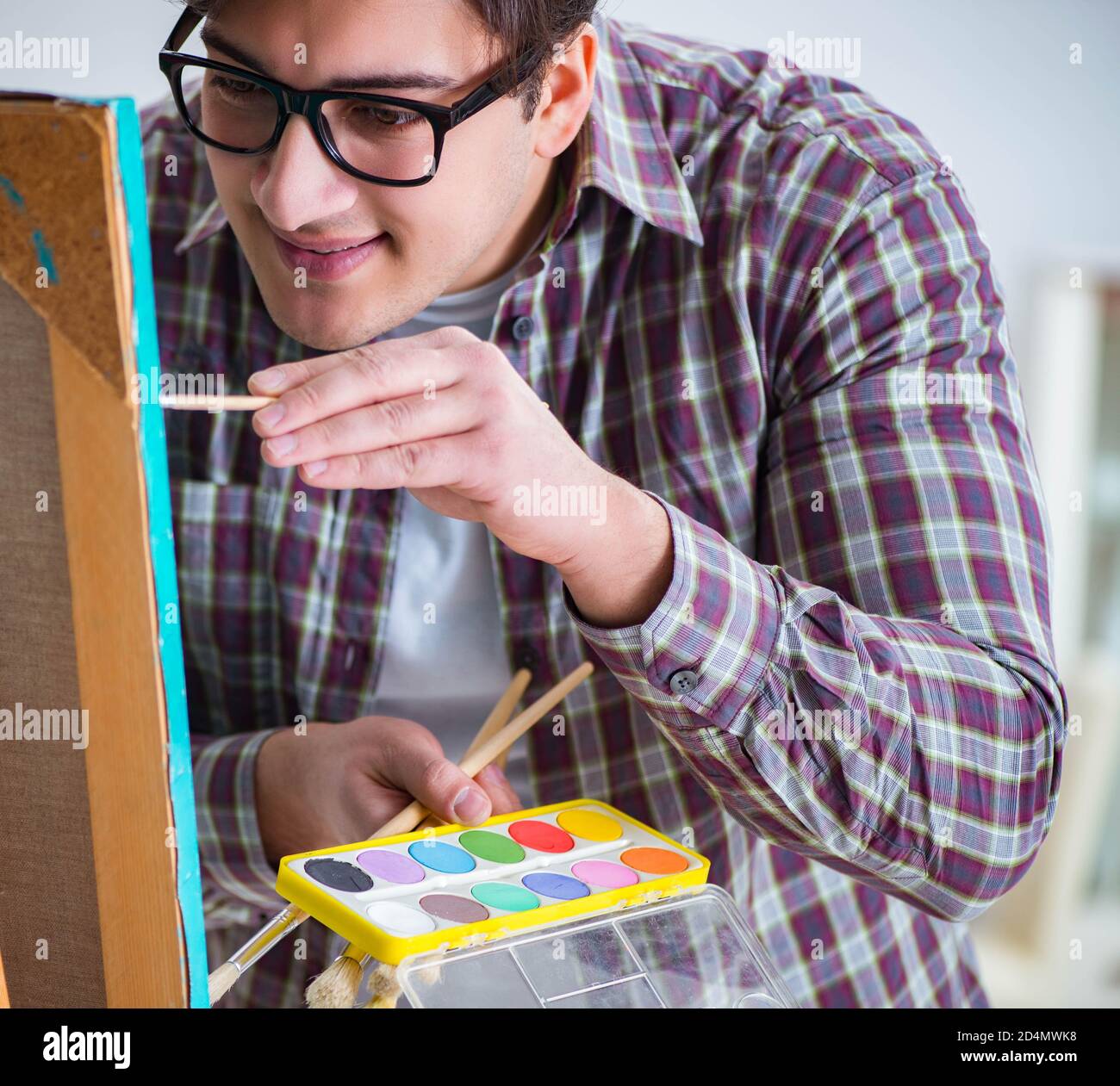 The young male artist drawing pictures in bright studio Stock Photo - Alamy