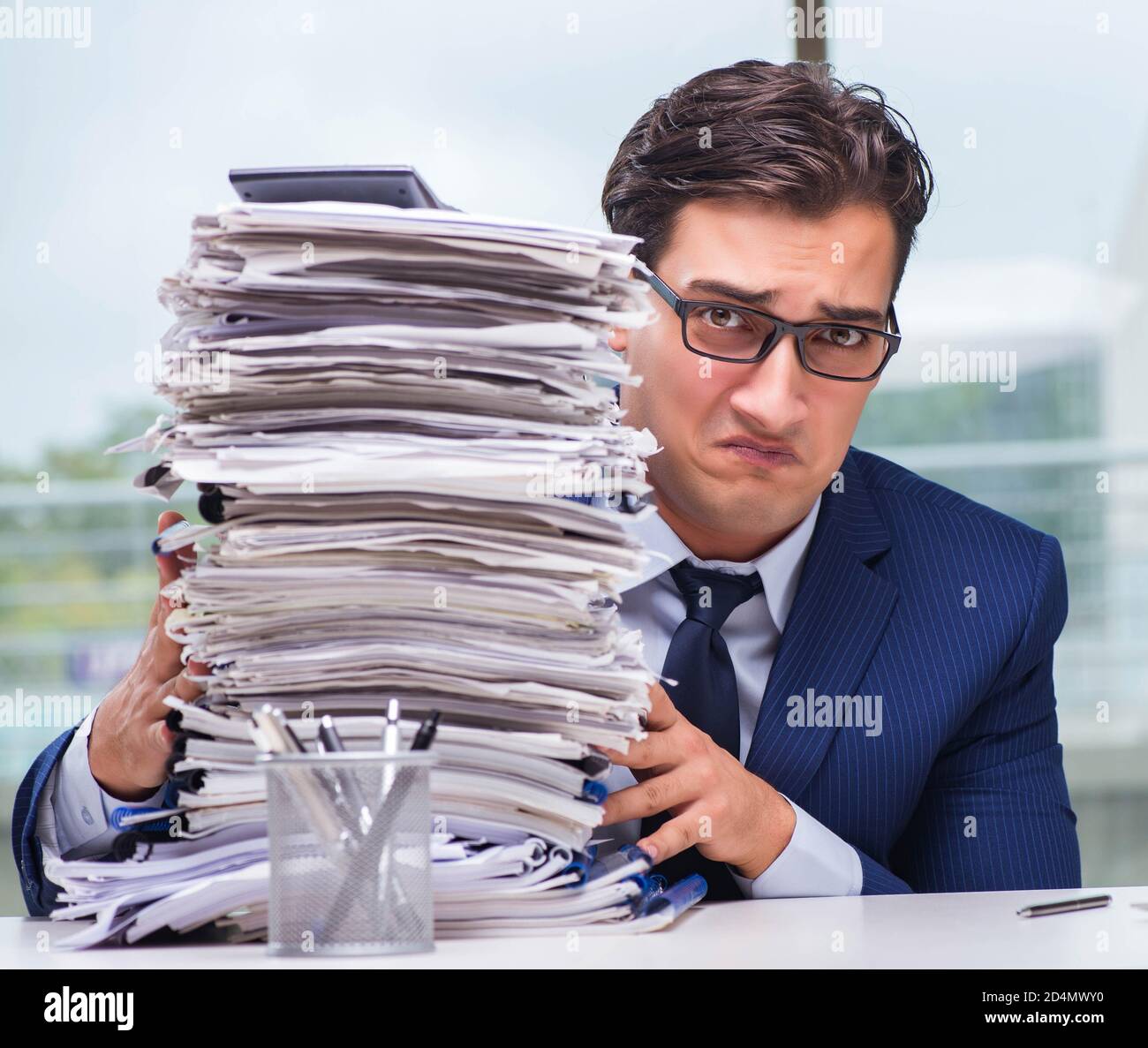 The businessman with pile stack of paper paperwork in the office Stock ...