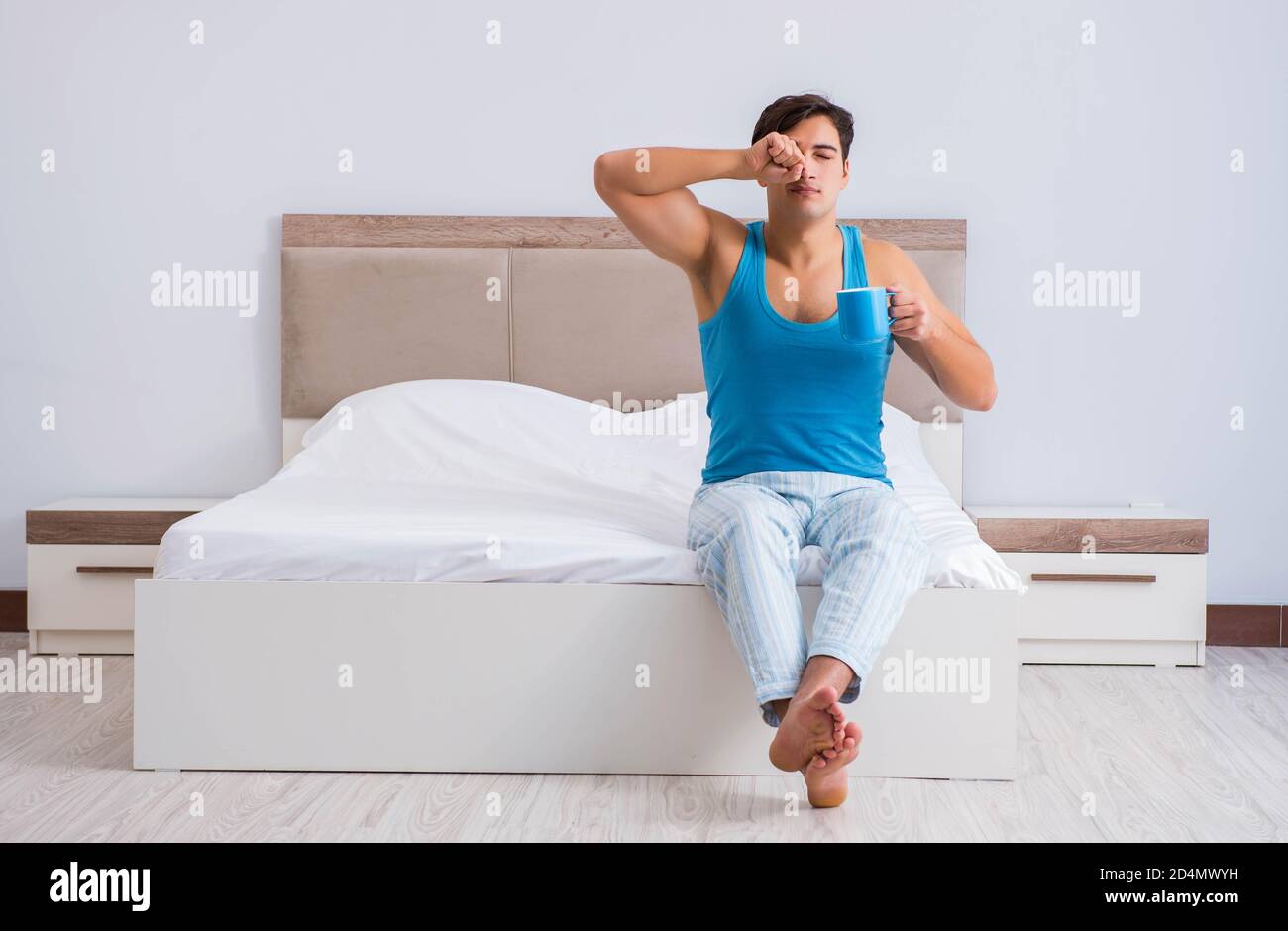 The young man waking up in bed Stock Photo - Alamy