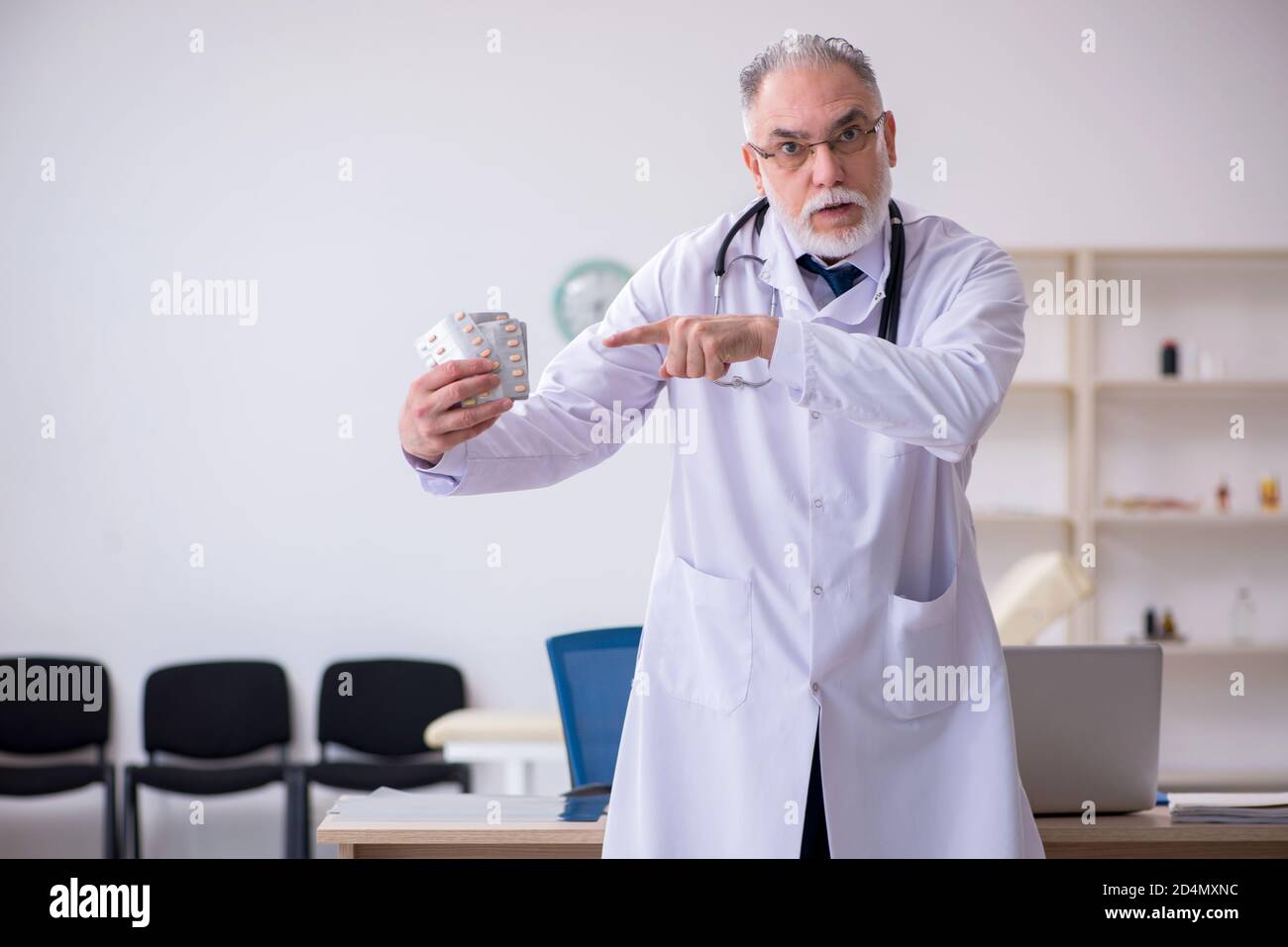 Old experienced doctor working in the clinic Stock Photo - Alamy