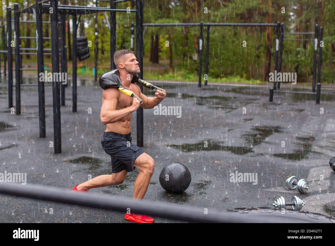 Outdoor workout under rain - man doing exercise lunges outdoors Stock ...