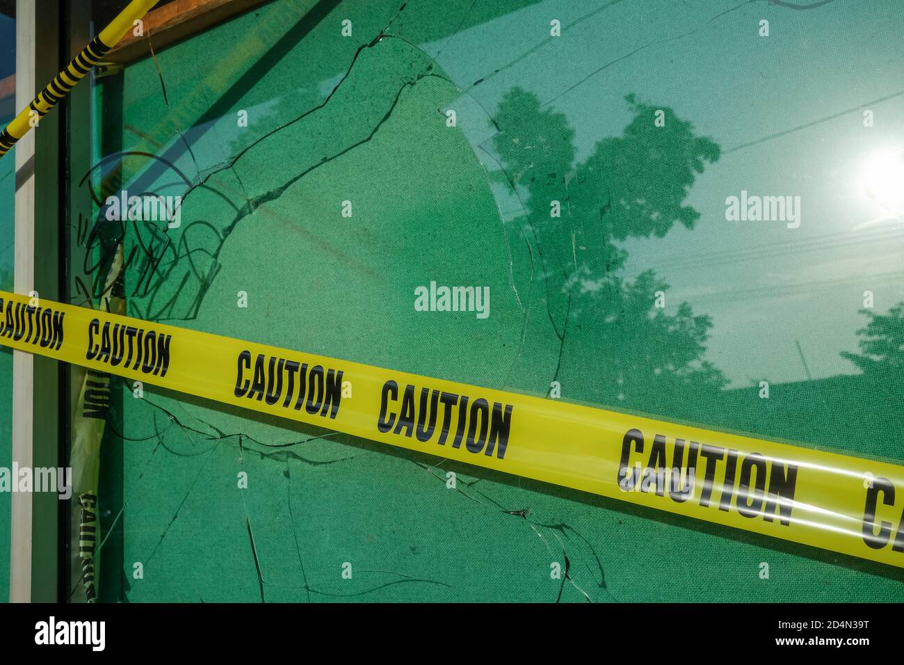 Broken shop window with a safety caution tape in front of it Stock ...