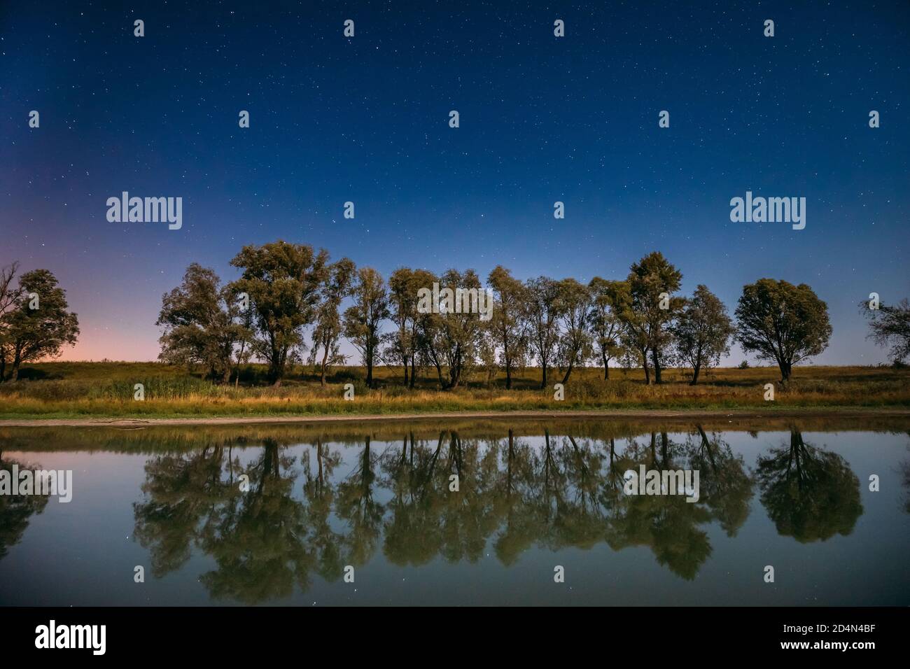 Blue Night Starry Sky Above Lake River. Night Glowing Stars And Trees ...