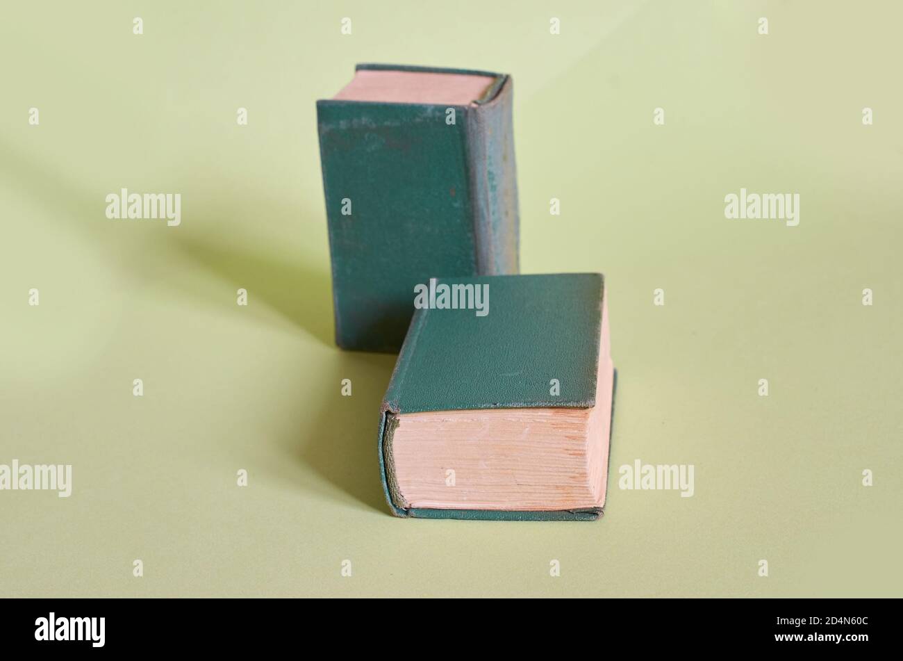 Two old books lie on a plain green background. Banner Stock Photo - Alamy