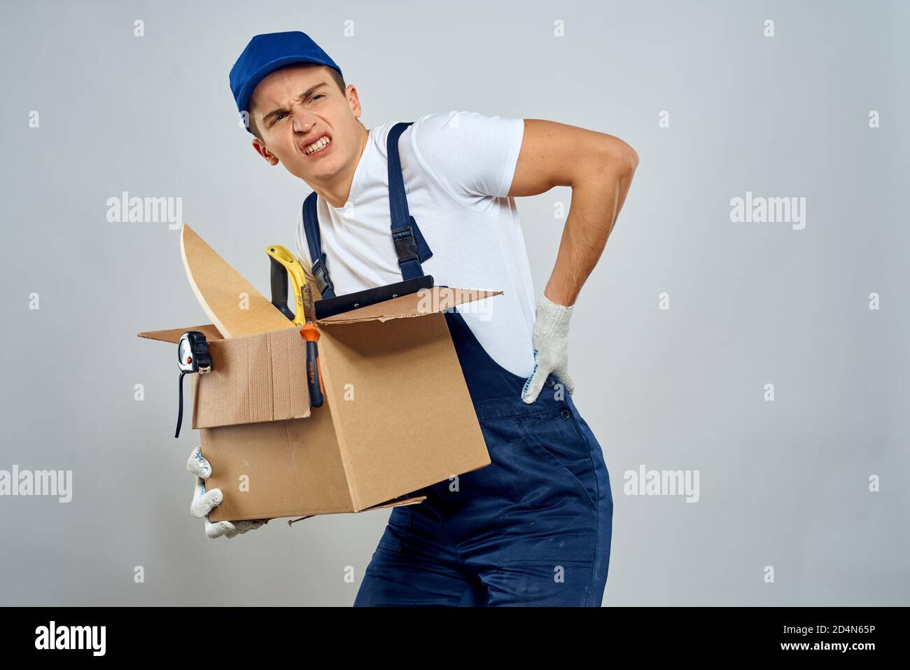man in working uniform with a box in his hands tools loader delivery ...