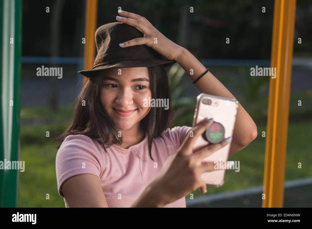 Latin lady wearing a hat smiling and doing a selfie Stock Photo - Alamy