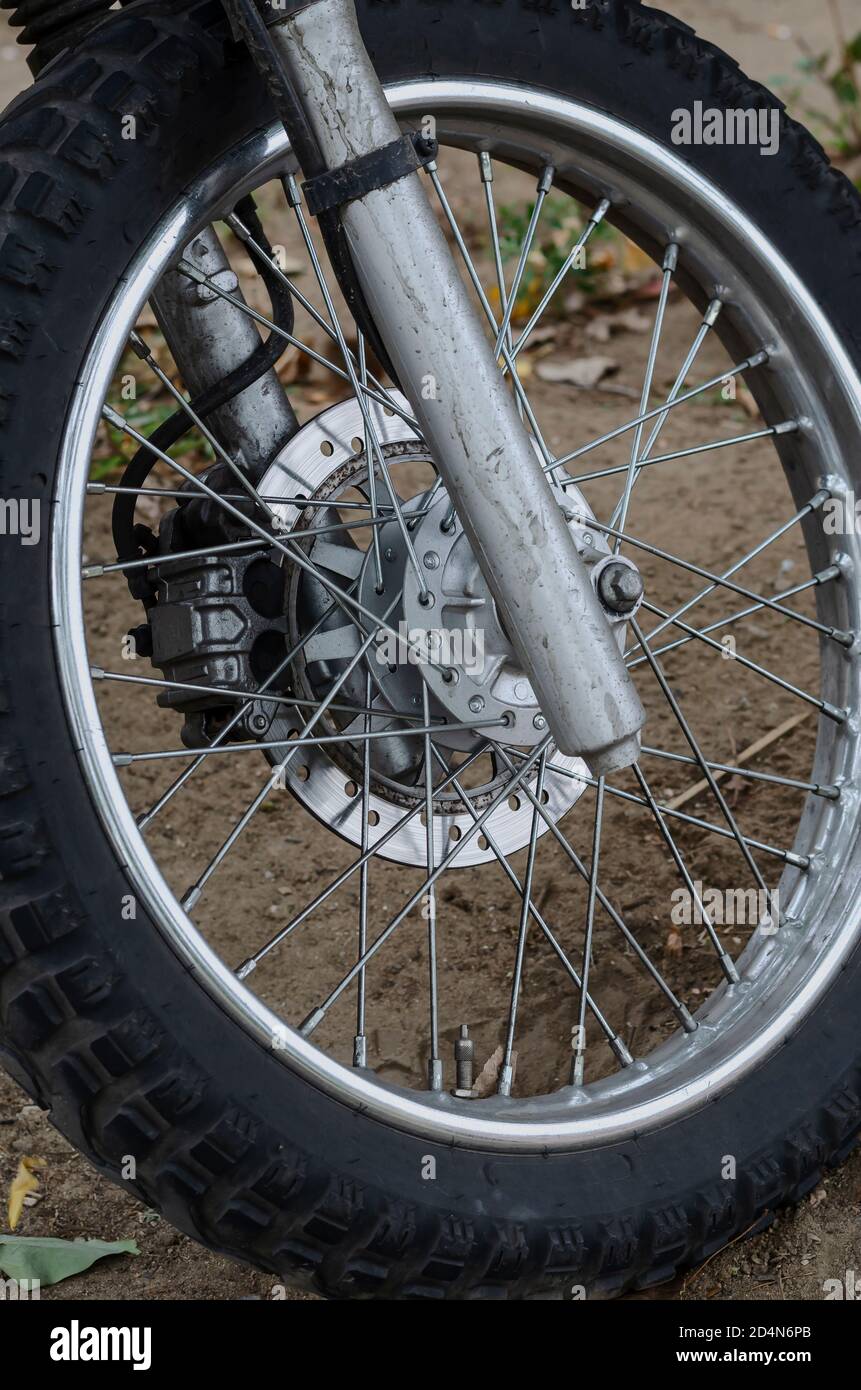 Close-up Front wheel of a mountain motorcycle standing on the ground ...