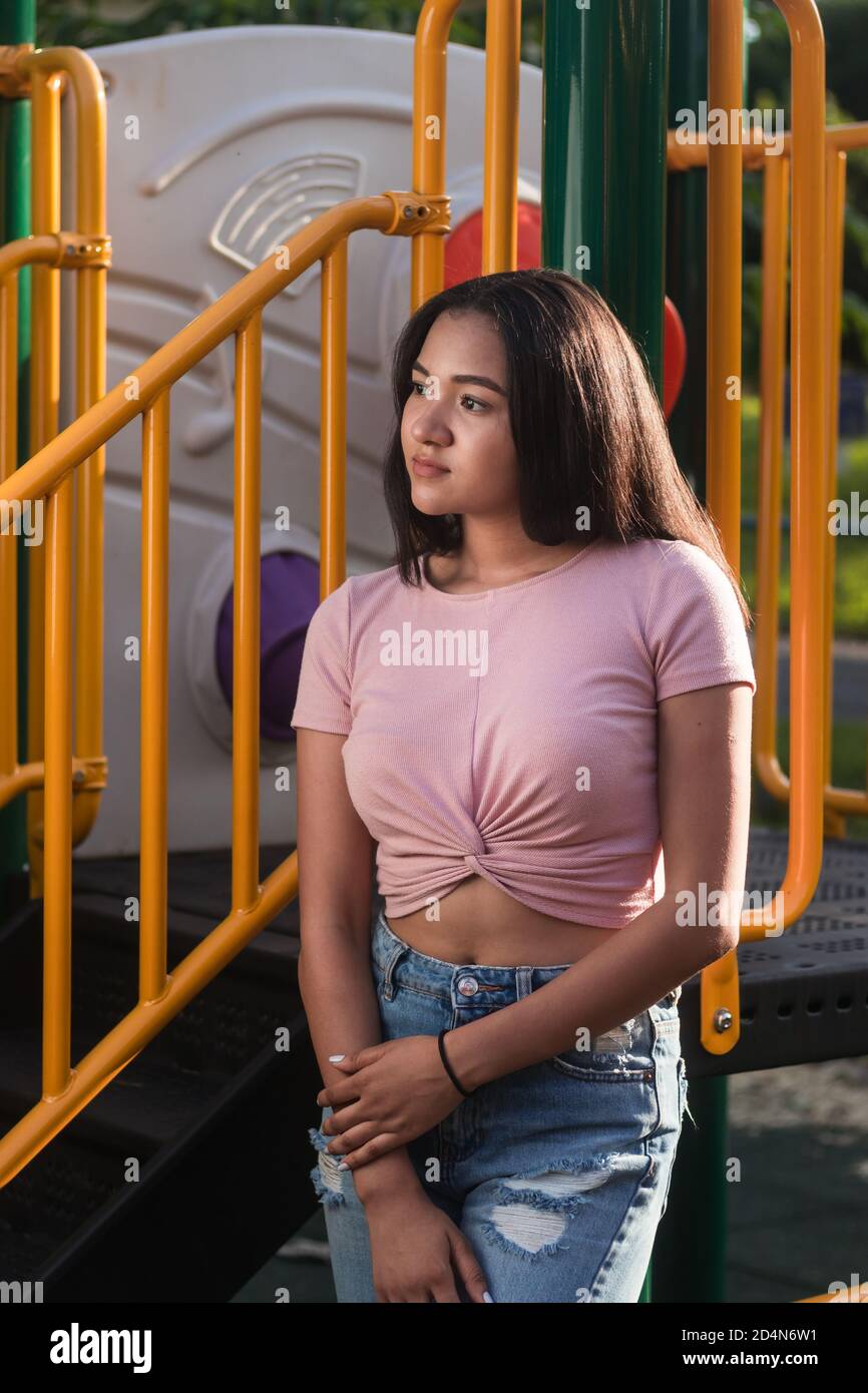 Vertical sot of a Latin young lady in the playground Stock Photo - Alamy