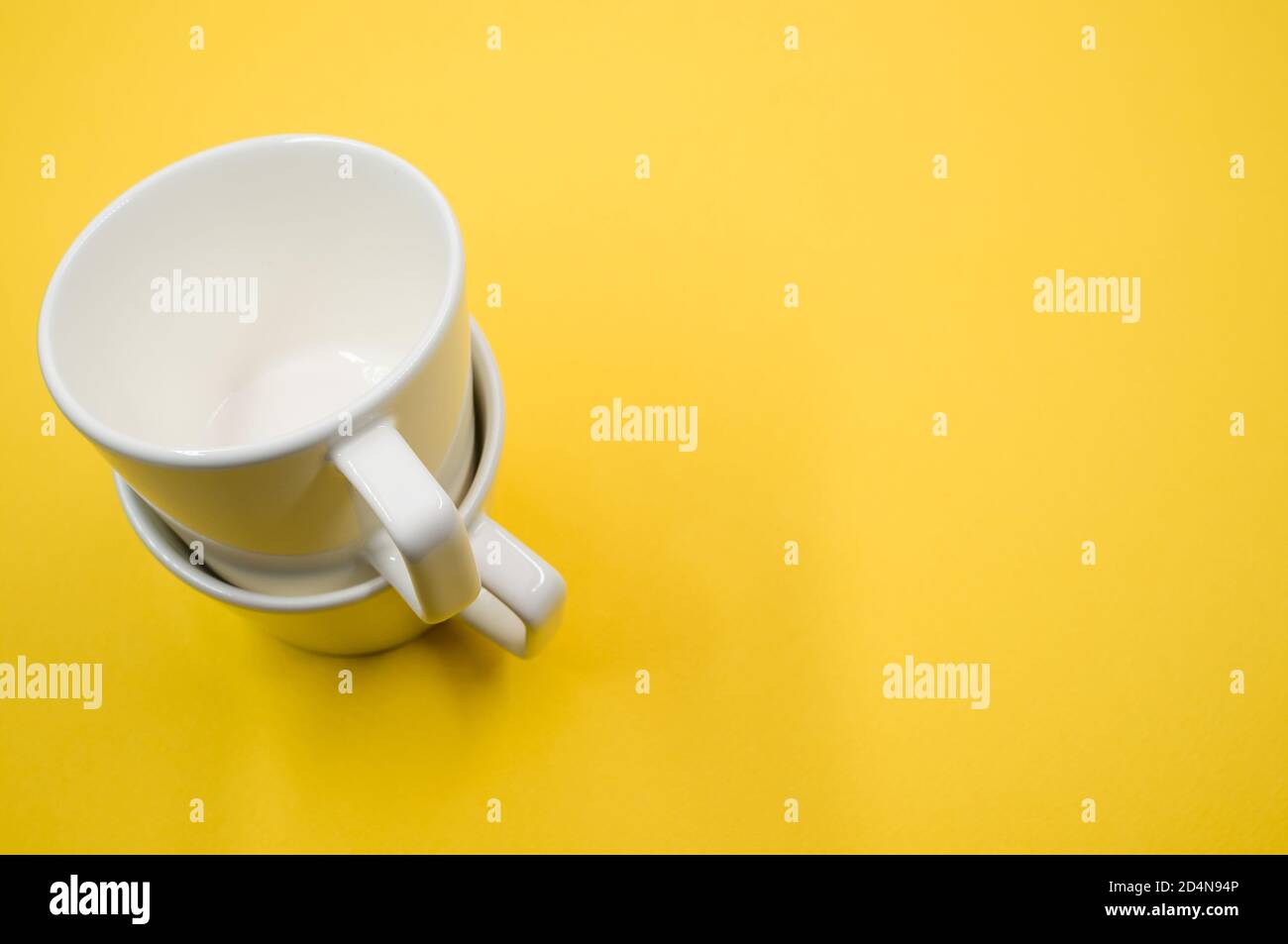 High angle shot of two empty cups on a yellow surface Stock Photo - Alamy