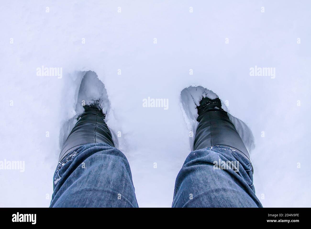 A steps in a deep snow. Legs in blue jeans in a drift Stock Photo - Alamy