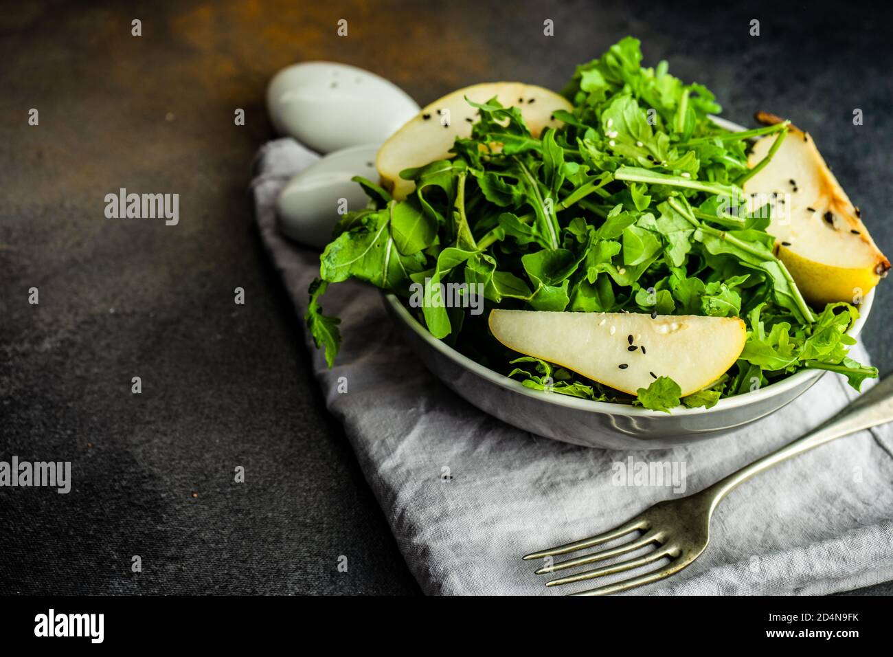 Organic food concept with fresh raw rucola leaves and pear slices with ...