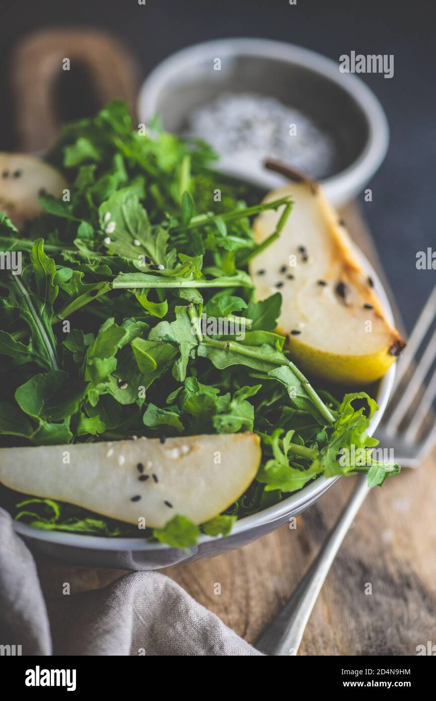 Organic food concept with fresh raw rucola leaves and pear slices with ...