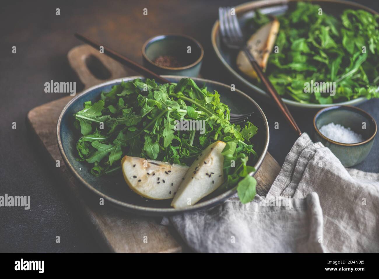 Organic food concept with fresh raw rucola leaves and pear slices with ...