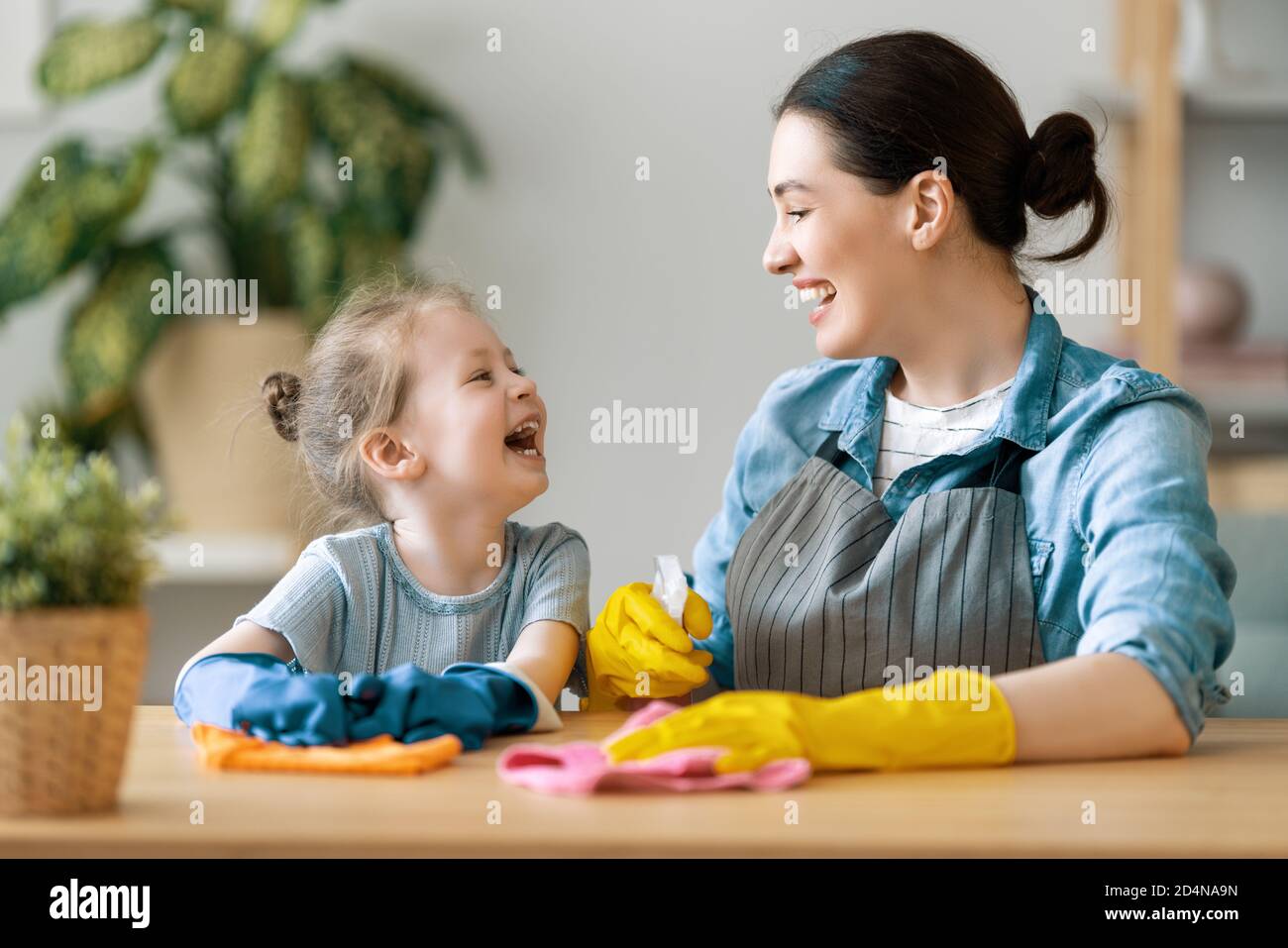 Happy family at home. Mother and daughter doing the cleaning in the ...