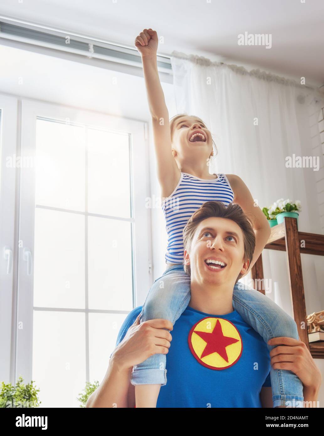 Father and his child playing together. Girl and dad in Superhero ...