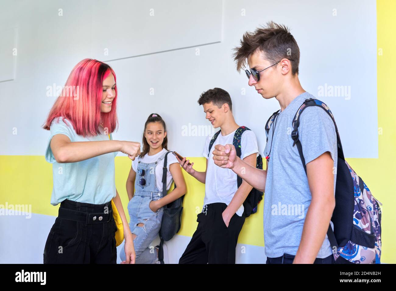 Teenagers in school greeting hand gestures when meeting Stock Photo - Alamy