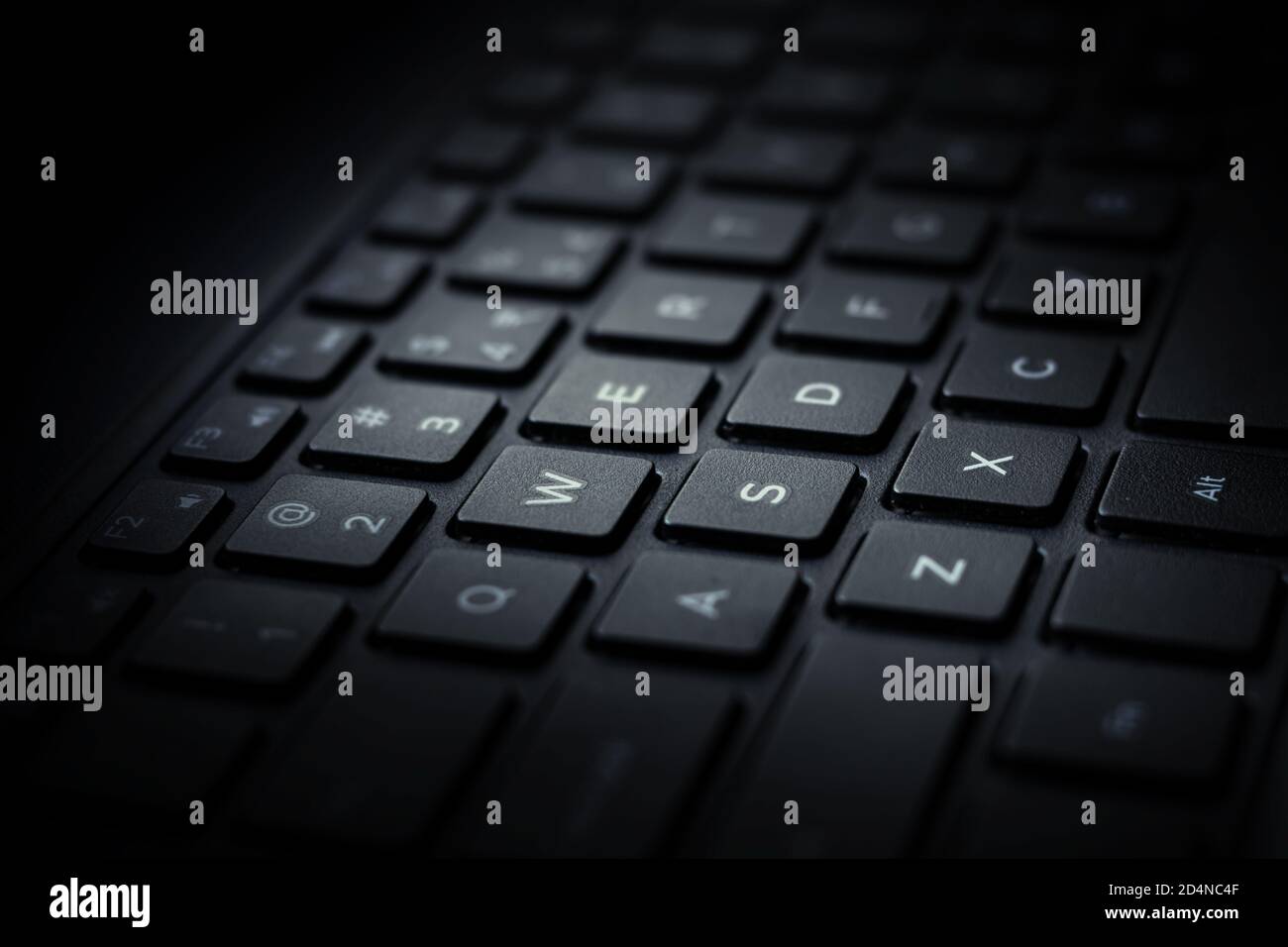 Closeup of black laptop QWERTY keyboard with light falling on keys ...