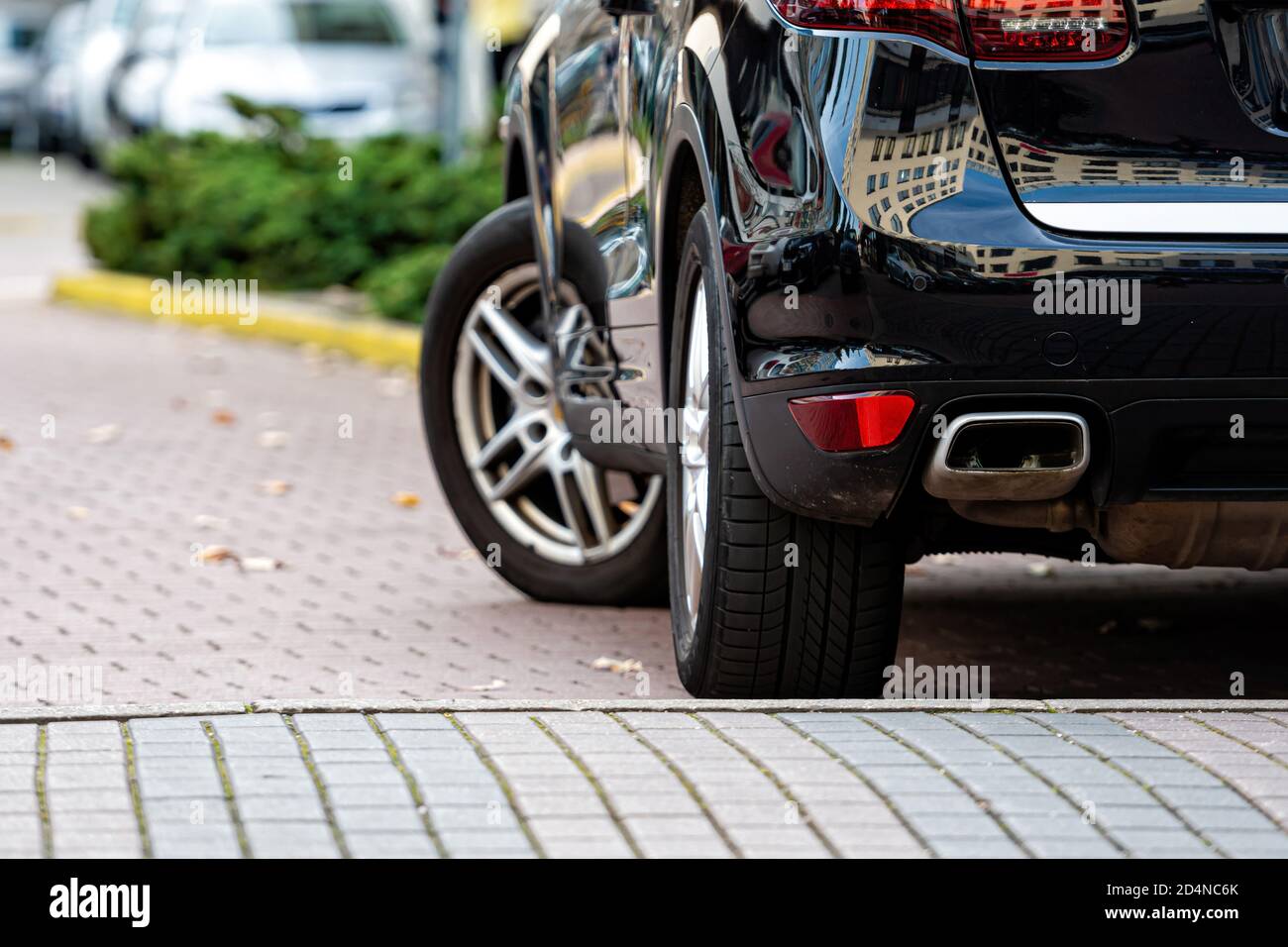 close-up view from behind of a black, shiny suv car parked on the ...