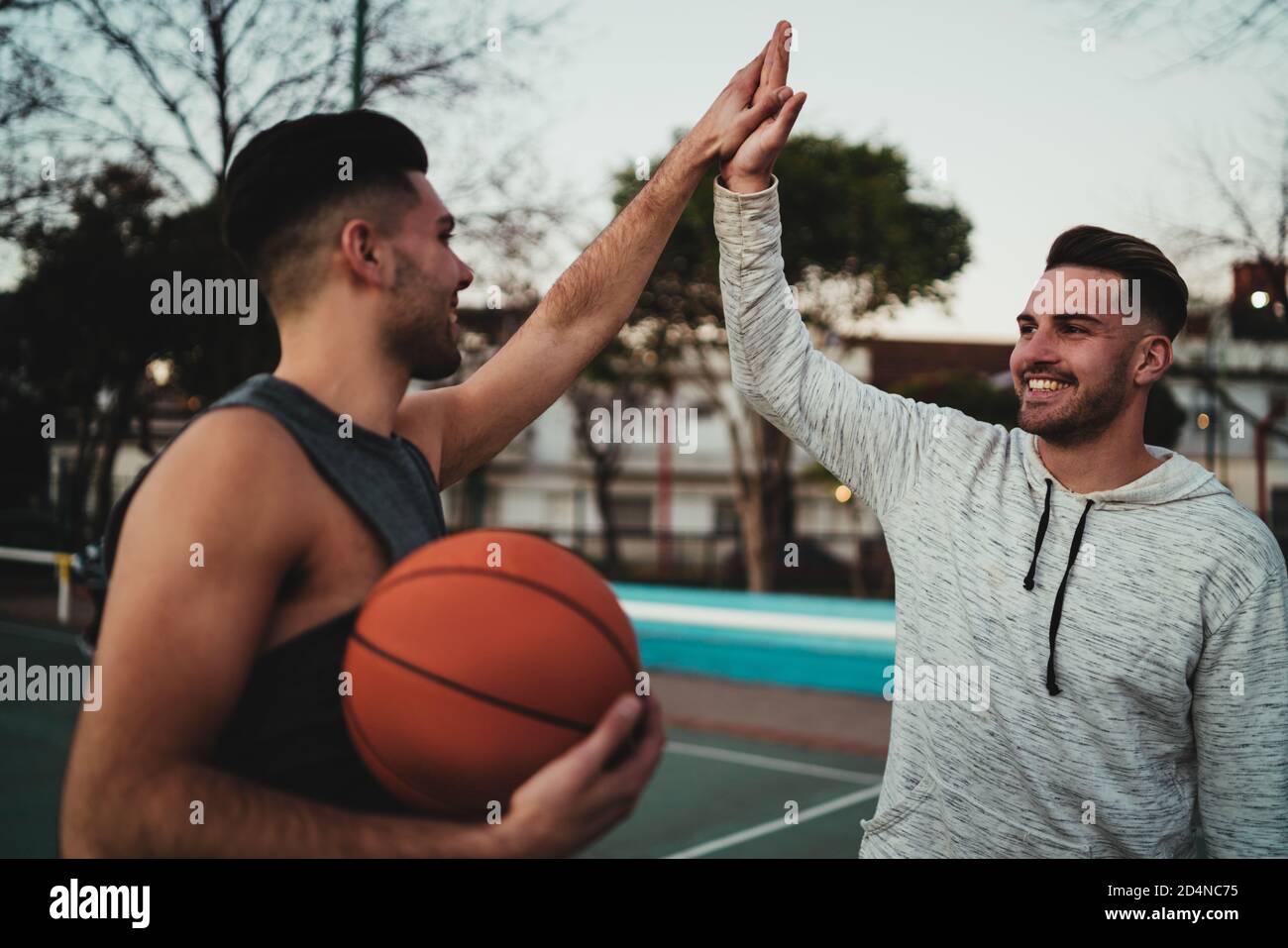 Portrait of two young friends playing basketball and having fun on ...