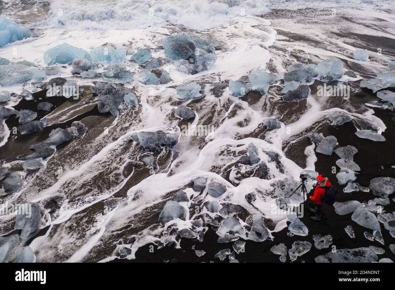 Red clothed man who photographing waves between ice rocks in famous ...