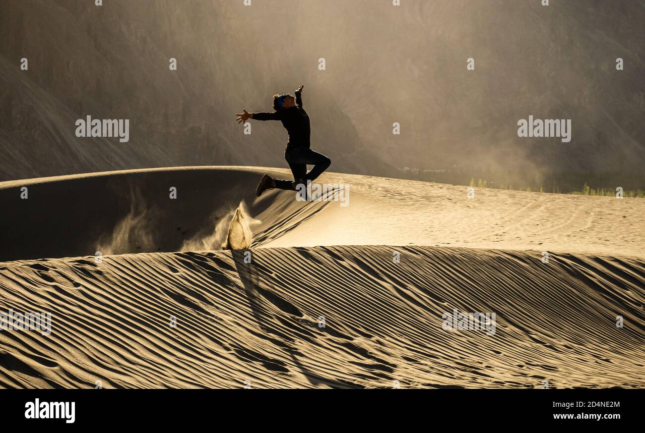 man jumping due to joy in Sand Dunes of Nubra Valley, Ladakh, India ...