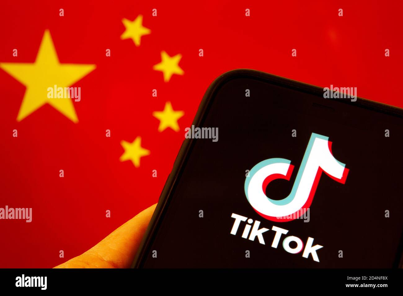 Cellphone with WeChat and TikTok icons in front of the flag of China ...