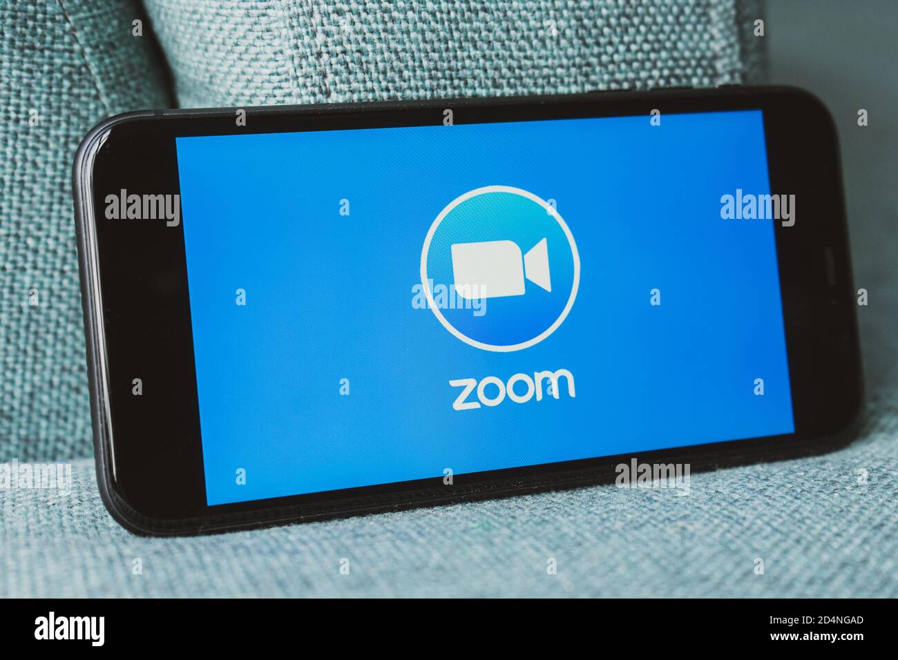 Phone with a hand showing Zoom Cloud Meetings app. Work and have ...
