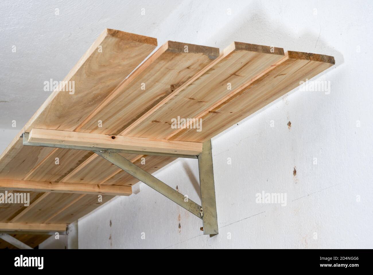 Close-up of a wooden shelf supported by a triangular iron frame on the ...