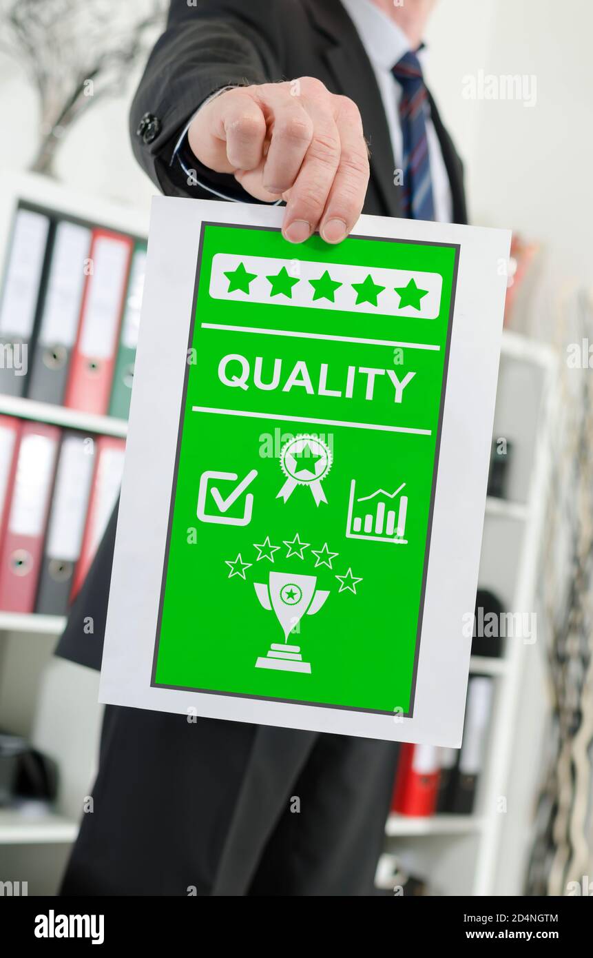 Paper showing quality concept held by a businessman Stock Photo - Alamy