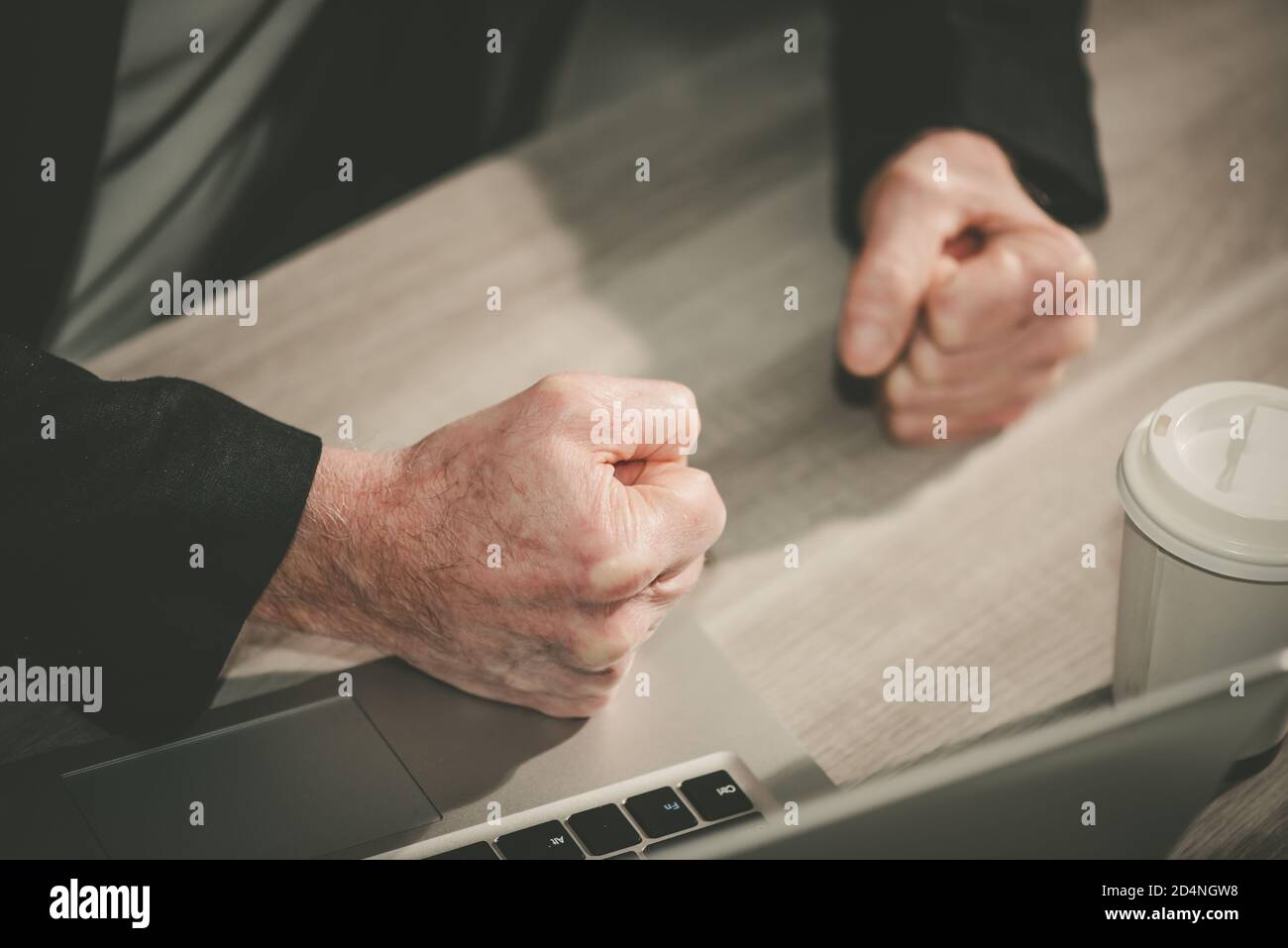Angry businessman hitting his desk with his clenched fists Stock Photo ...
