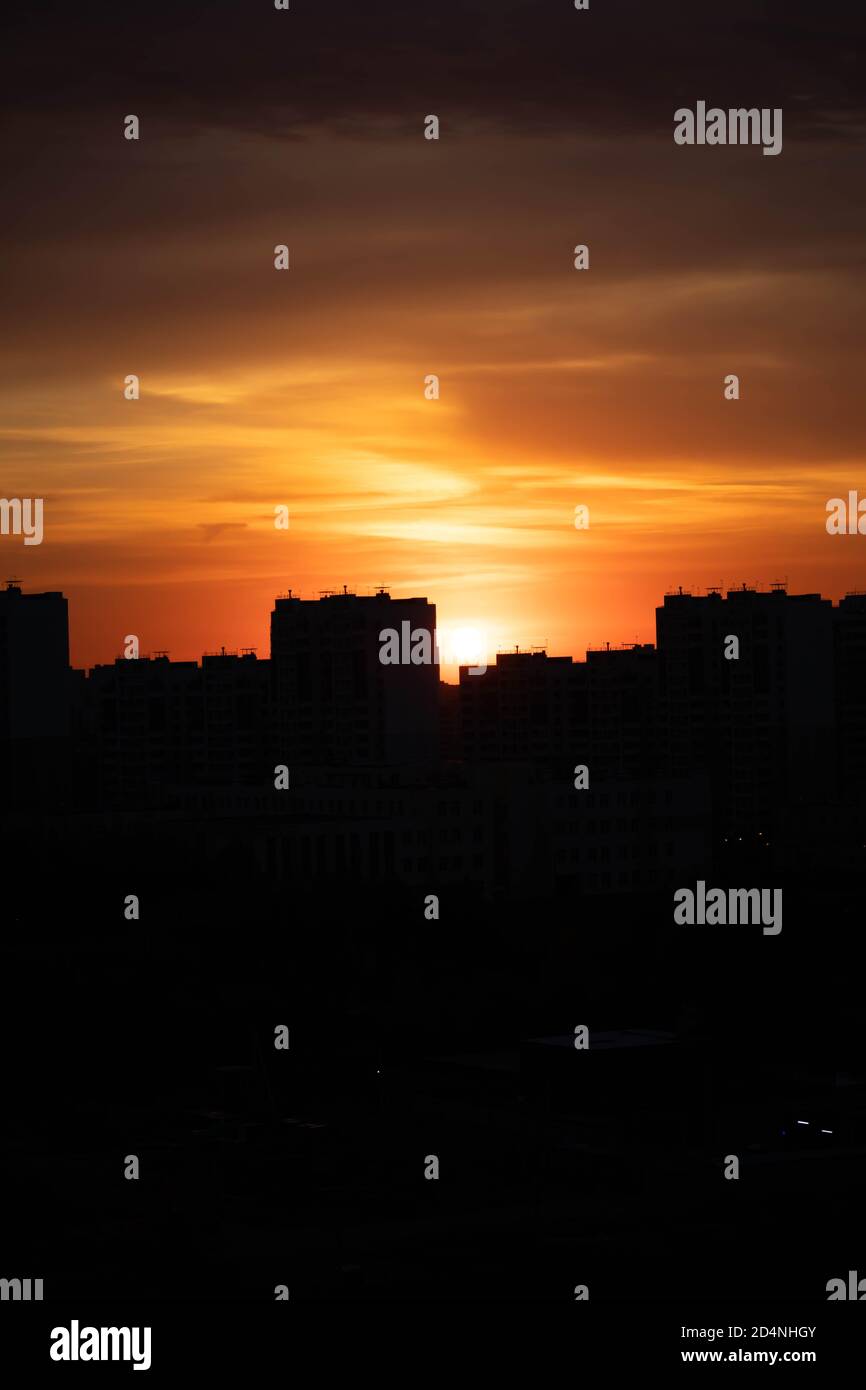 Big city in the rays of the sunset. High-rise black houses and red ...