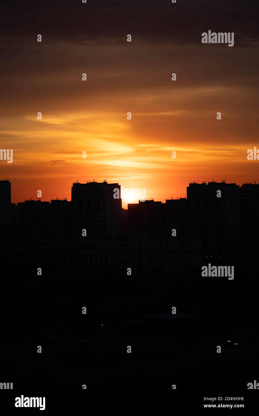 Big city in the rays of the sunset. High-rise black houses and red ...