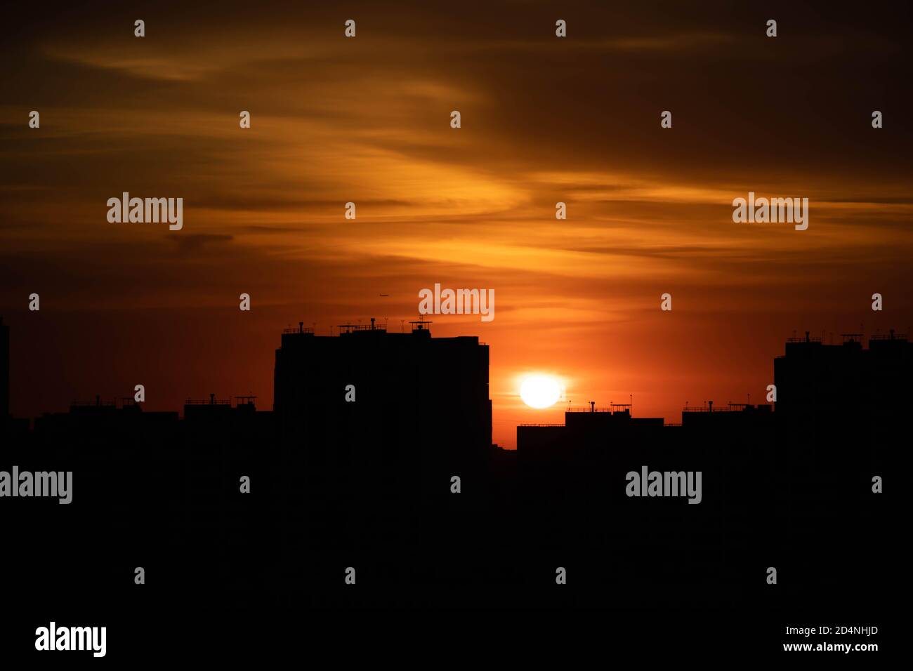 Big city in the rays of the sunset. High-rise black houses and red ...