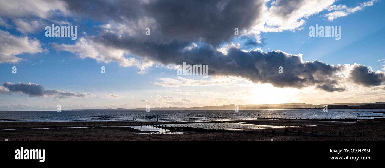 Exmouth beach looking towards Dawlish at sunset with dramatic skies ...