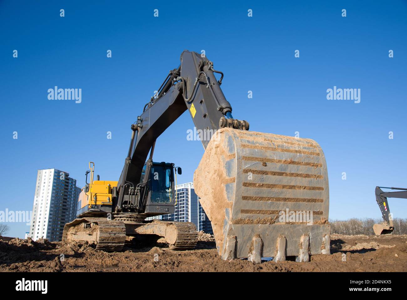 Excavator during earthmoving at construction site on blue sky ...