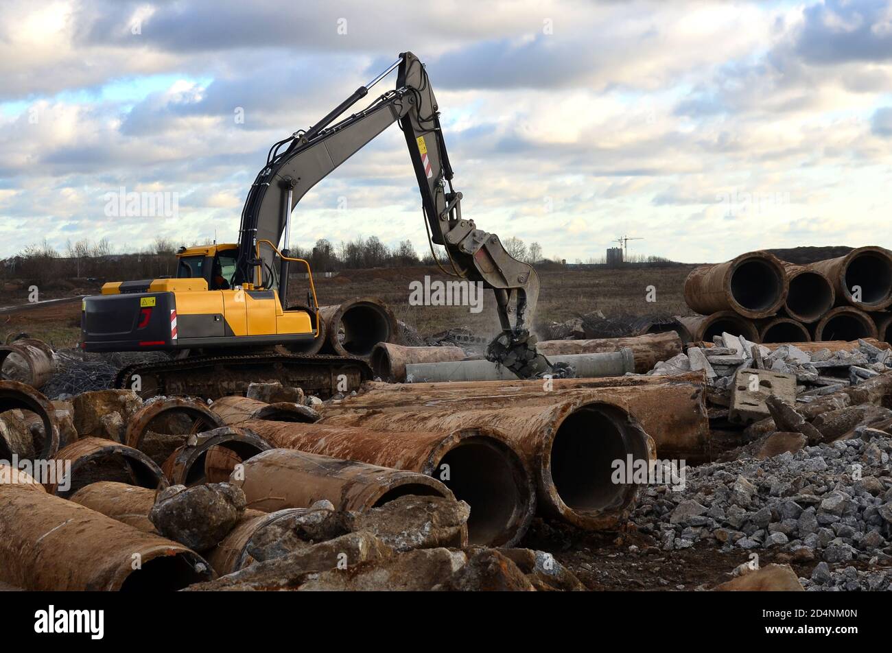 Excavator with hydraulic shears on a construction site cuts and ...